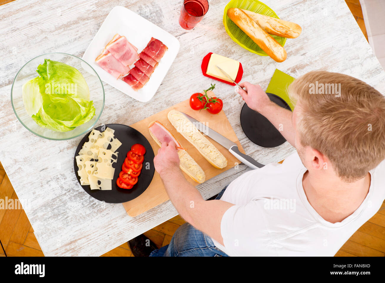 A young man preparing a sandwich in the kitchen Stock Photo - Alamy