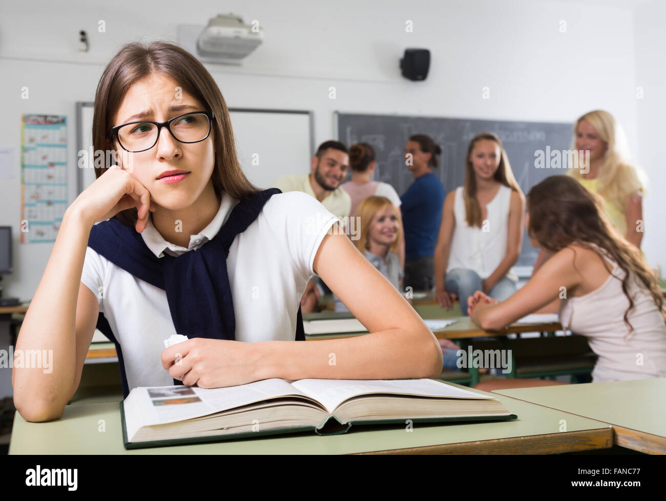 Alone american student being bullied by a group of students her chin on ...