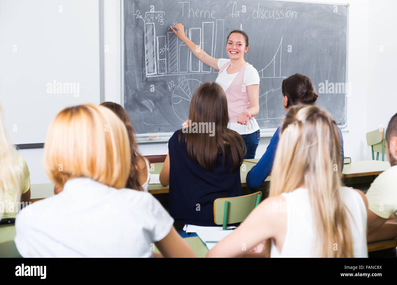 Ecxited smiling student gives answer near blackboard during lesson ...