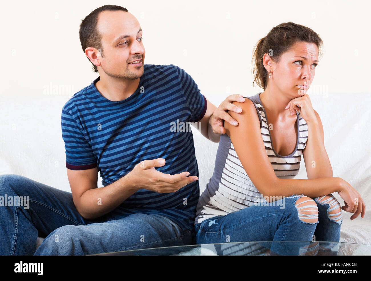 Sad partner asking unhappy another for forgiveness at home Stock Photo ...
