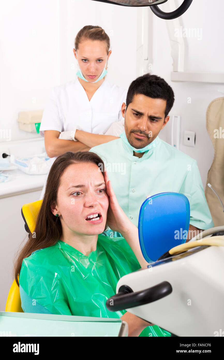 Sad patient detecting problems on inspection at the dentist. Focus on ...
