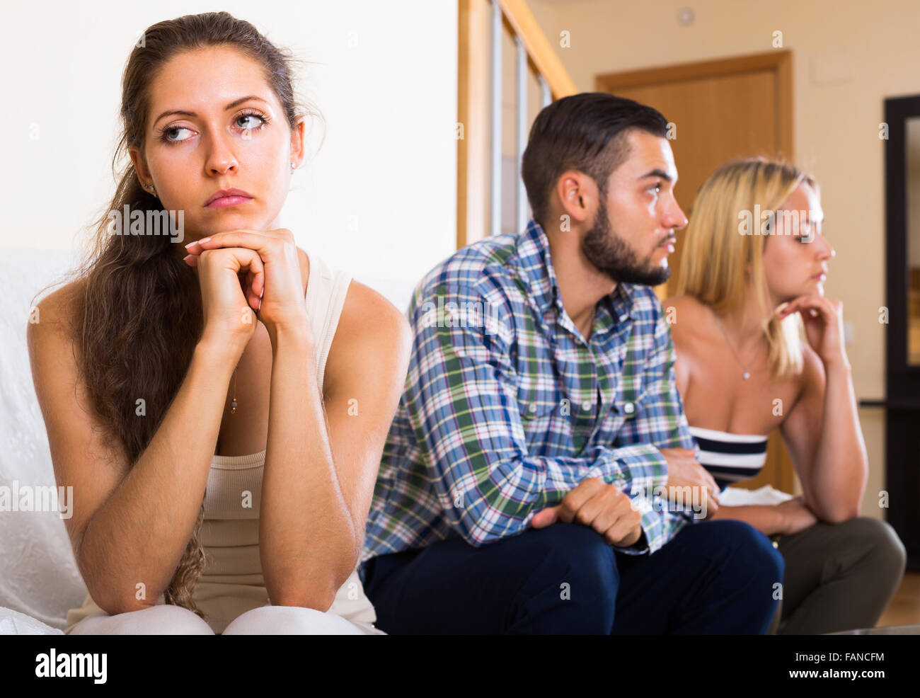 Three young adults having conflict at domestic interior Stock Photo - Alamy