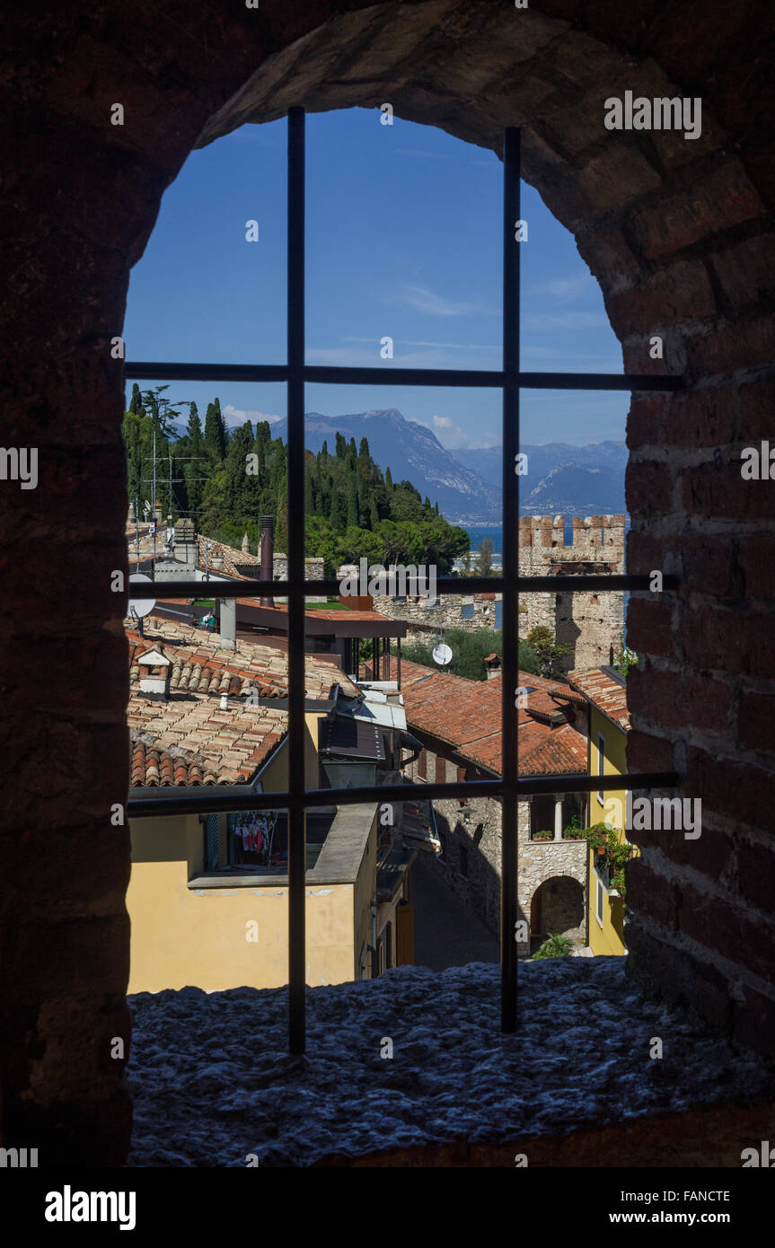 View on Lake Garda (Italy) and Sirmione old city through ancient window ...