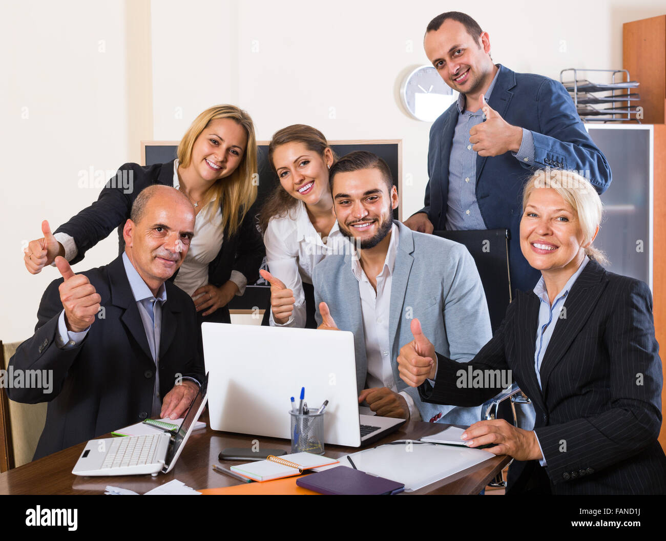 positive colleagues looking at laptop and smiling Stock Photo - Alamy