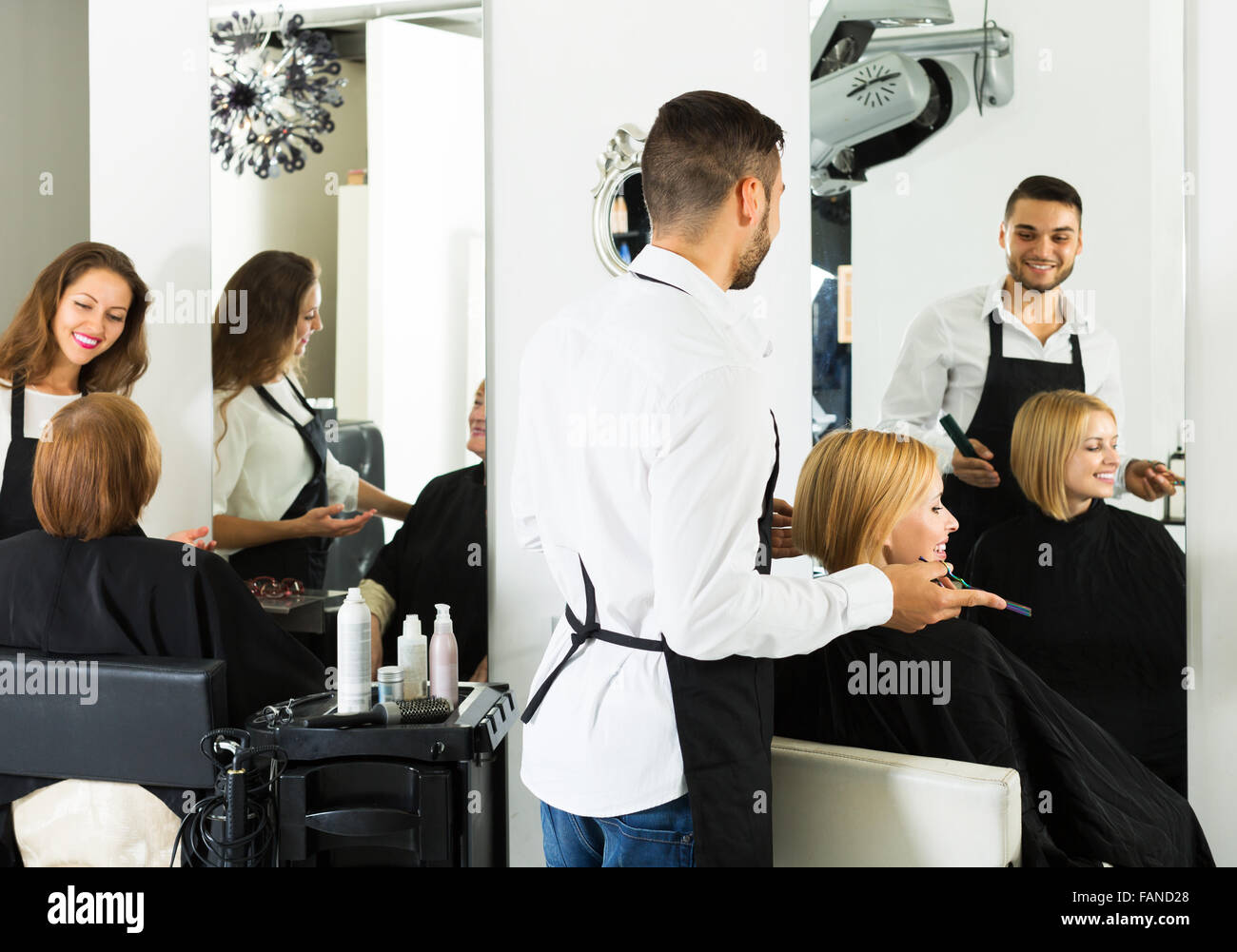 Professional young man hairdresser doing hairstyle for young men Stock ...