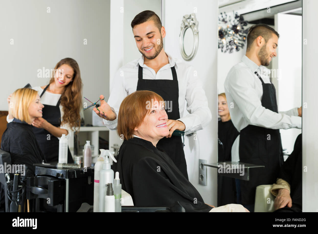 Elderly woman cuts hair at the hair salon with barber Stock Photo - Alamy