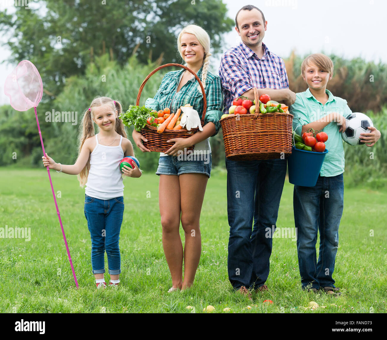 Smiling family of four having rest at countryside Stock Photo - Alamy