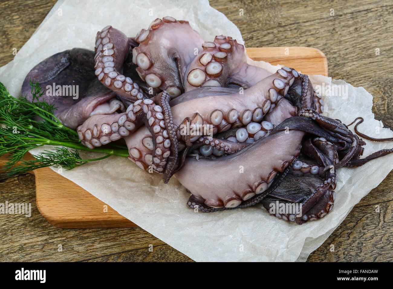 Raw octopus on the wood background ready for cooking Stock Photo - Alamy