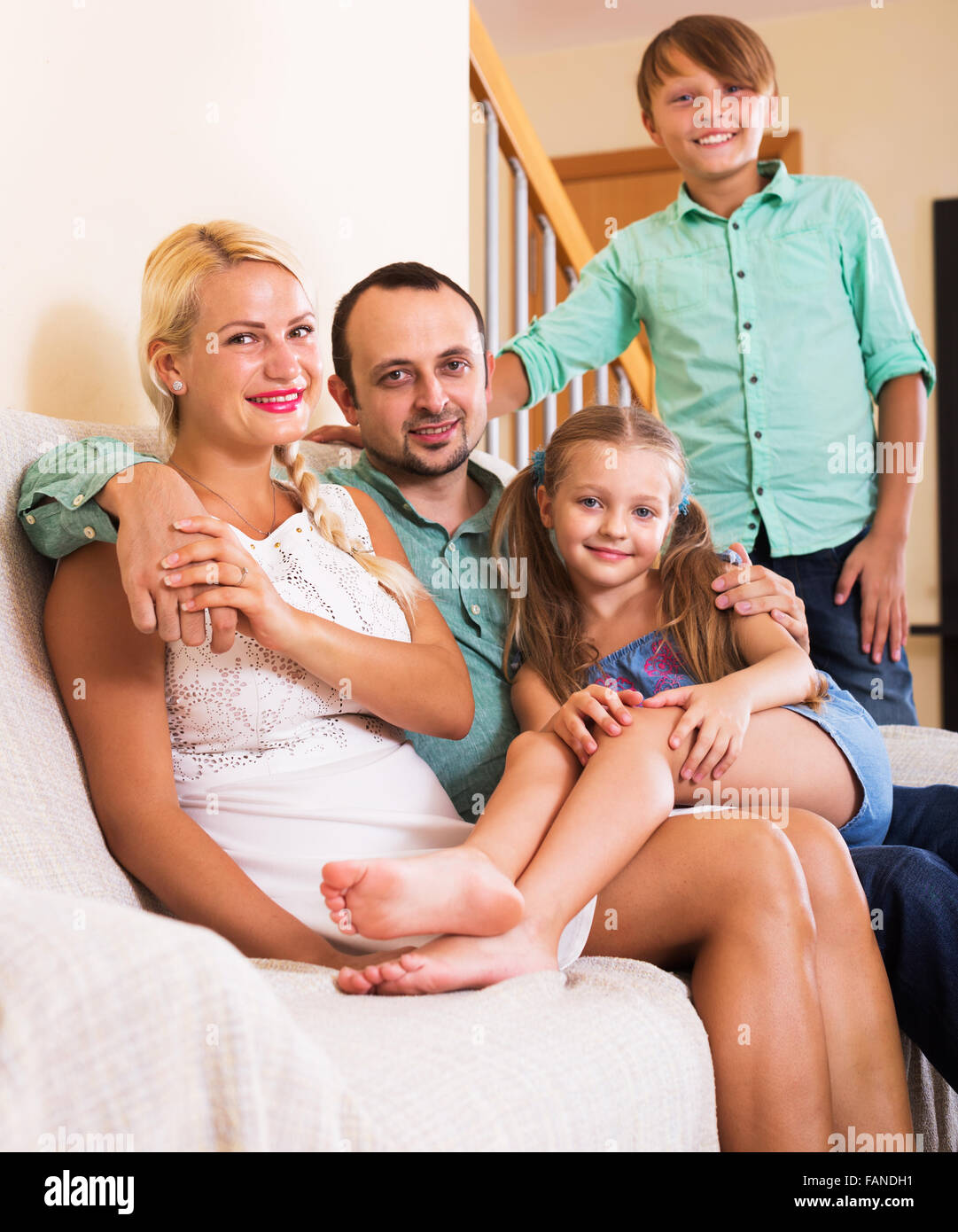 Portrait of happy middle class family with two children at home. Focus ...