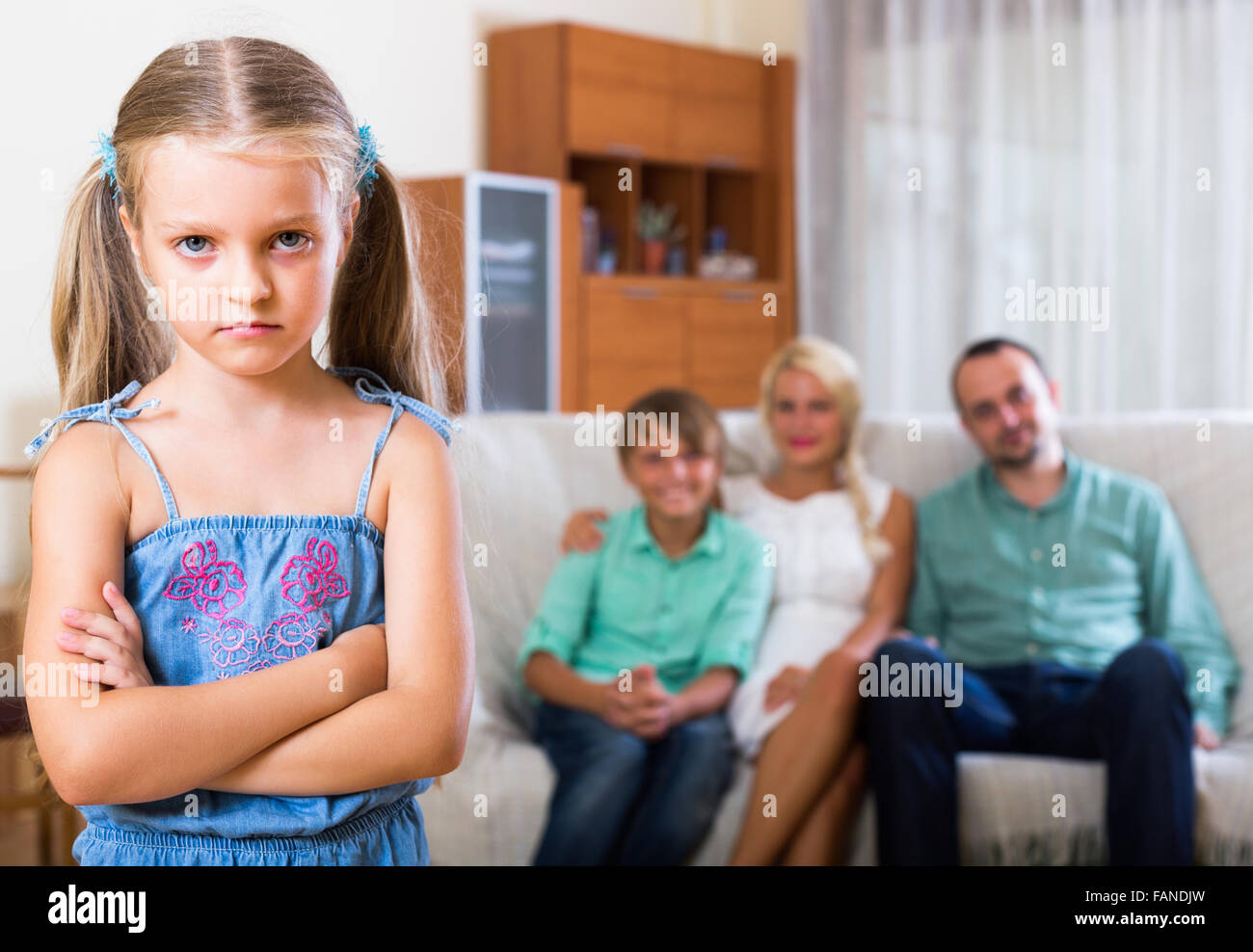 Cute little girl offended by the parents at home Stock Photo - Alamy