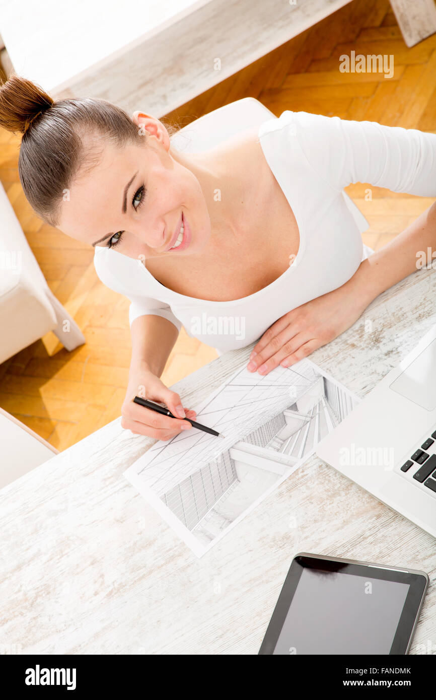 A young adult woman developing a architectural plan at home Stock Photo ...