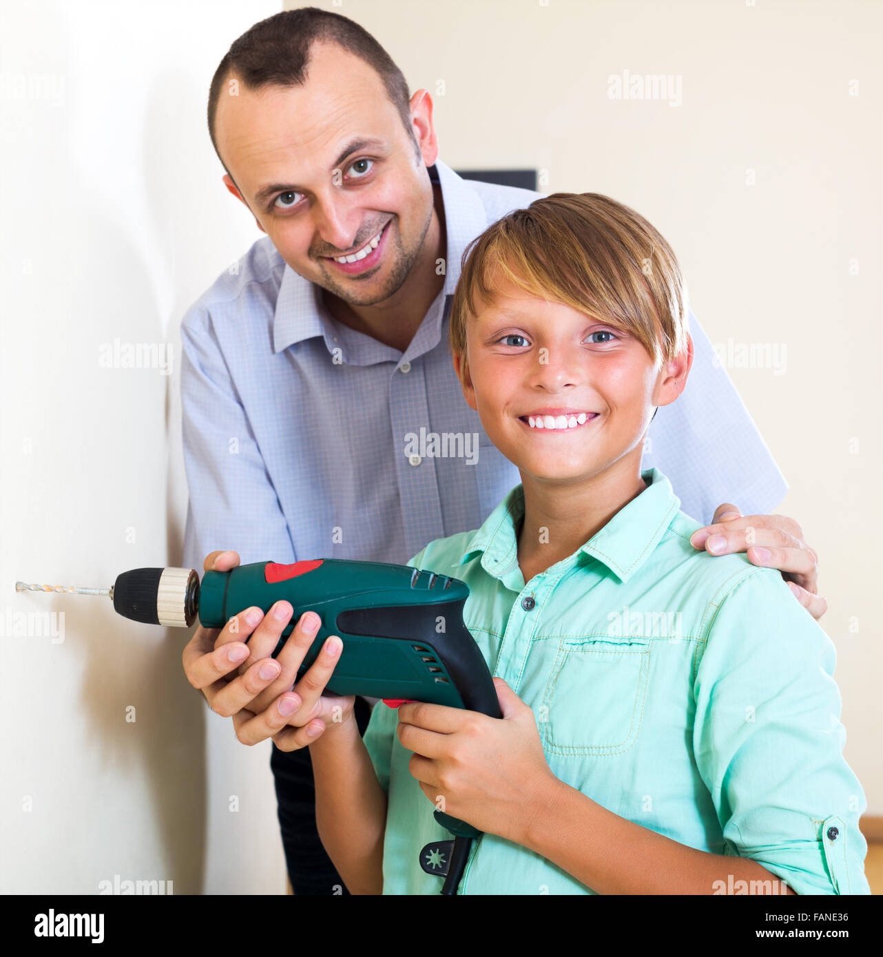 Adult man and boy using electric drill while interior renovation. Focus ...