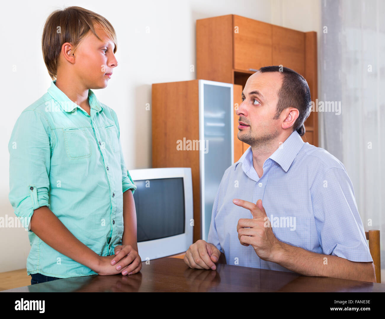 Offended man arguing about problems with teenage son Stock Photo - Alamy