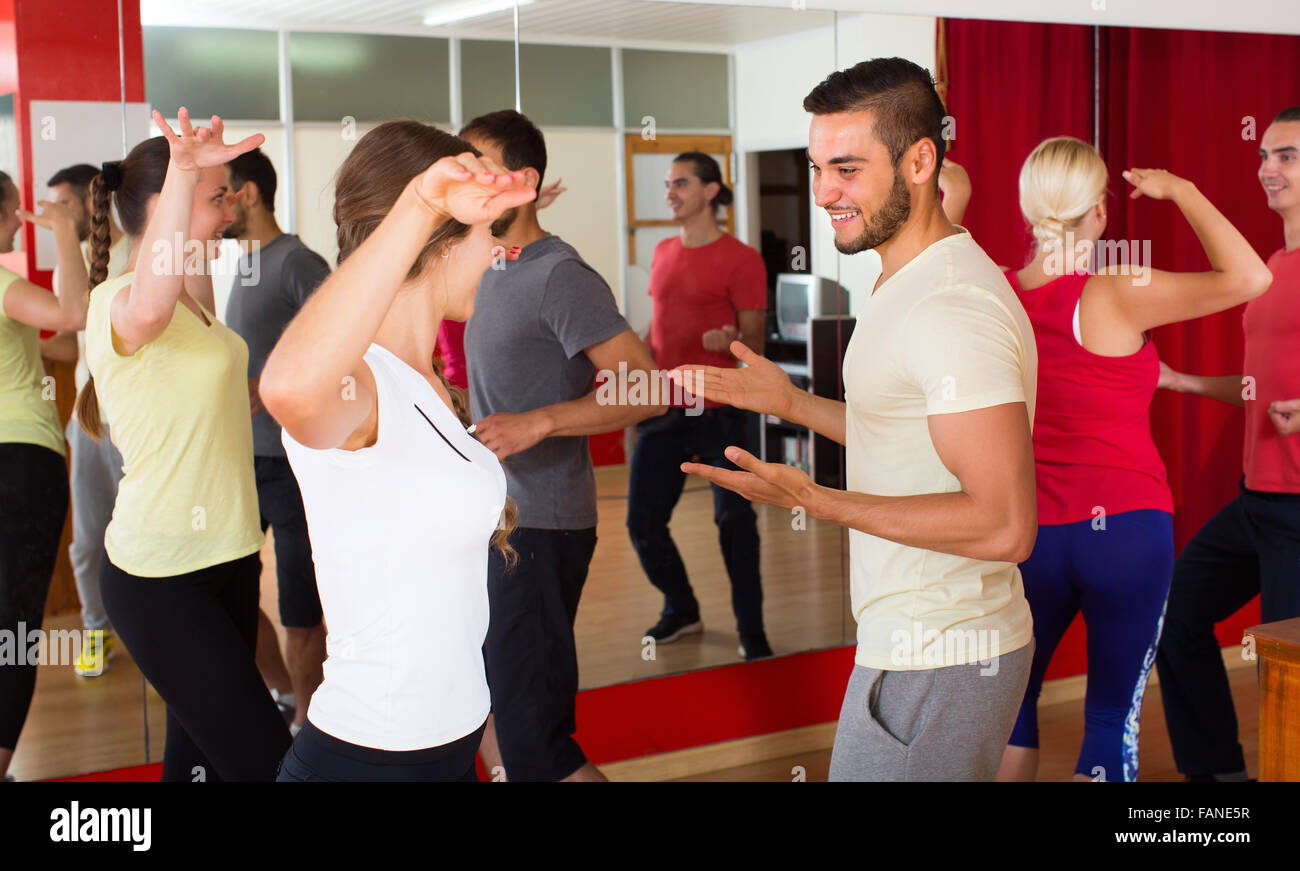 Cheerful young couples dancing active dance in studio. Selective focus ...