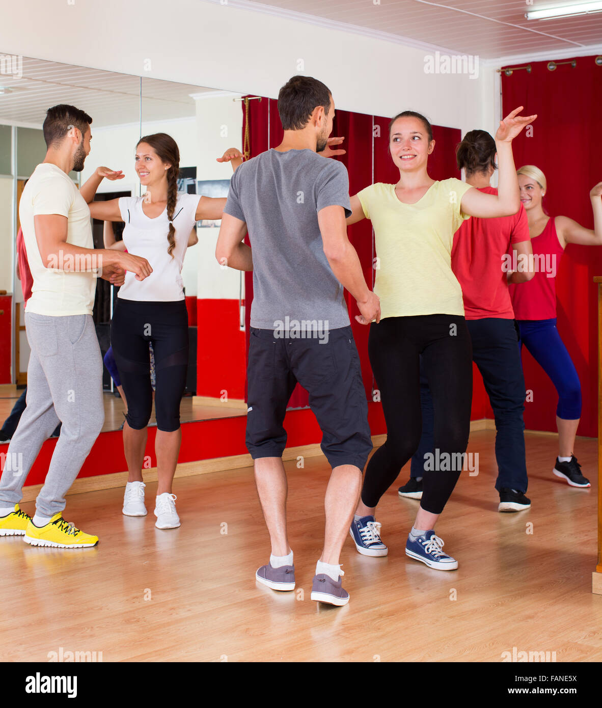 Happy men and women enjoying active dance at dance studio Stock Photo ...