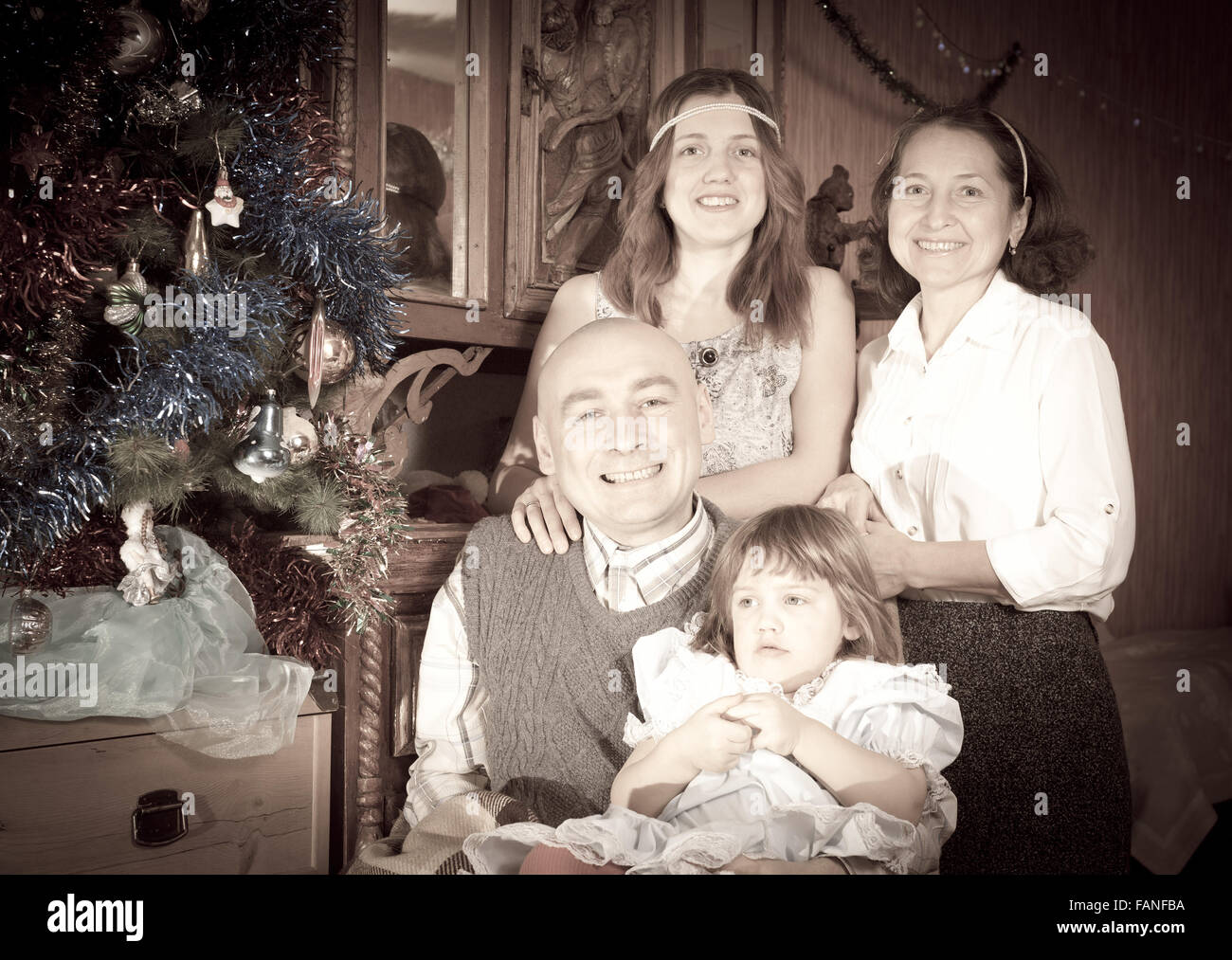 Retro photo of happy family of three generations at home with Christmas ...