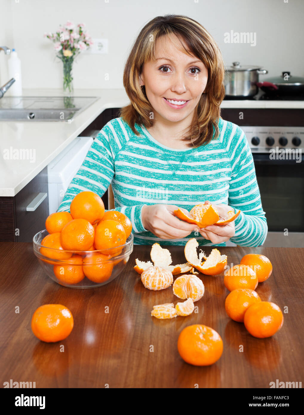 Woman eating tangerines in home Stock Photo - Alamy