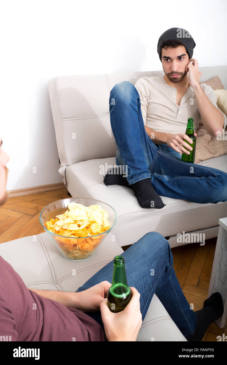 Two young men drinking beer at home Stock Photo - Alamy