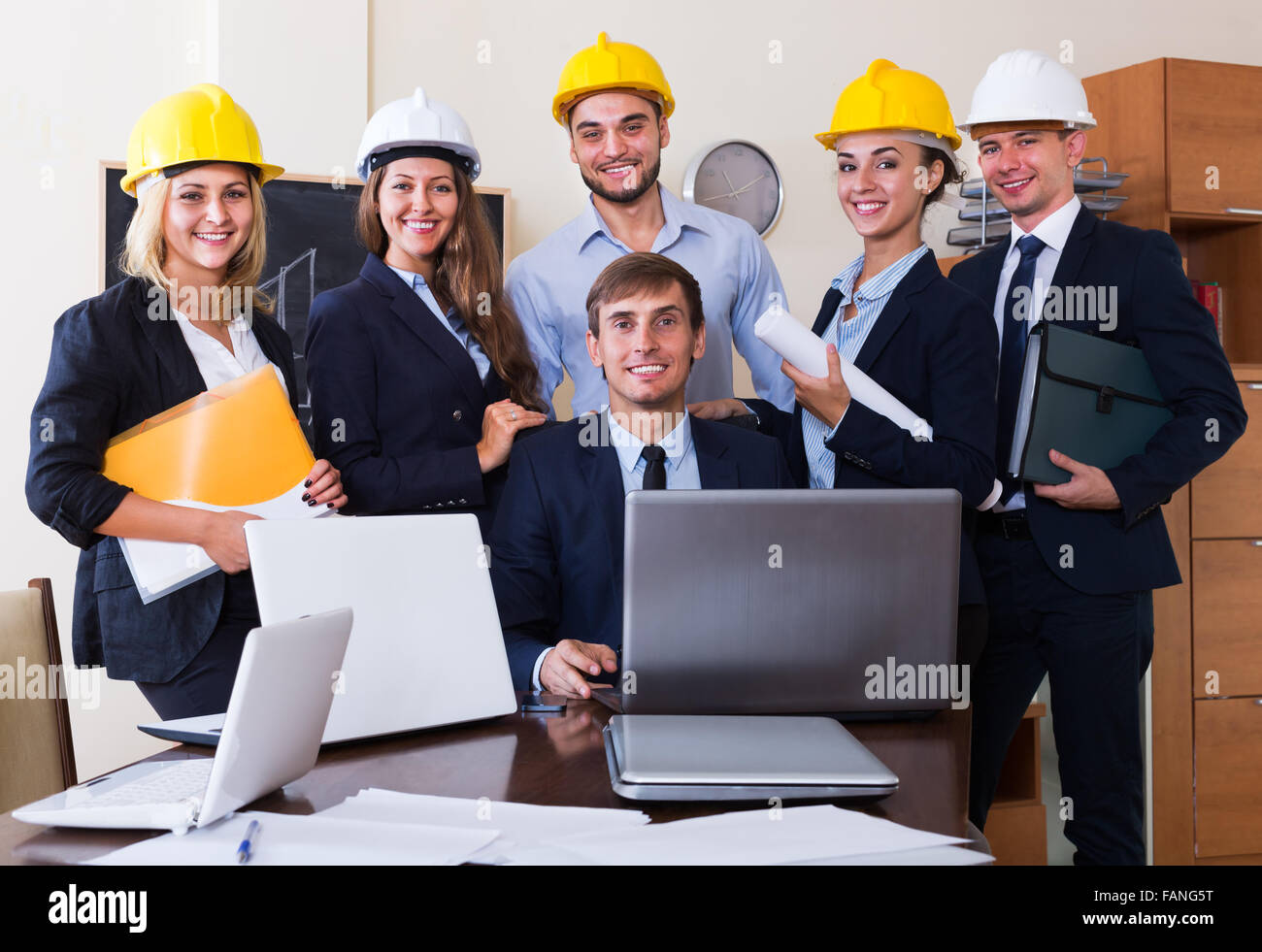 Professional planners with helmets posing at the architecture bureau ...