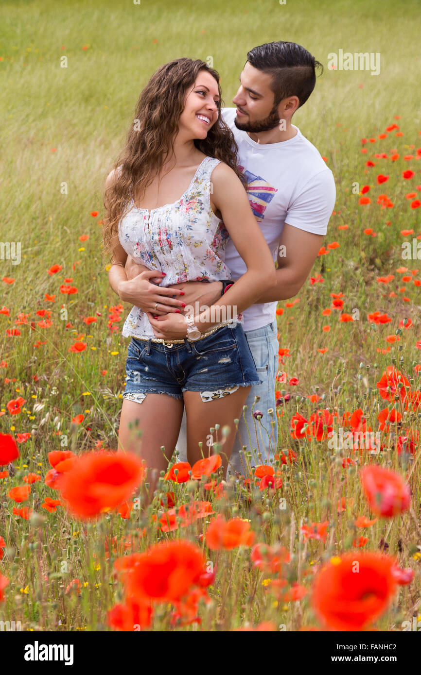 Portrait of happy couple in red poppies Stock Photo - Alamy