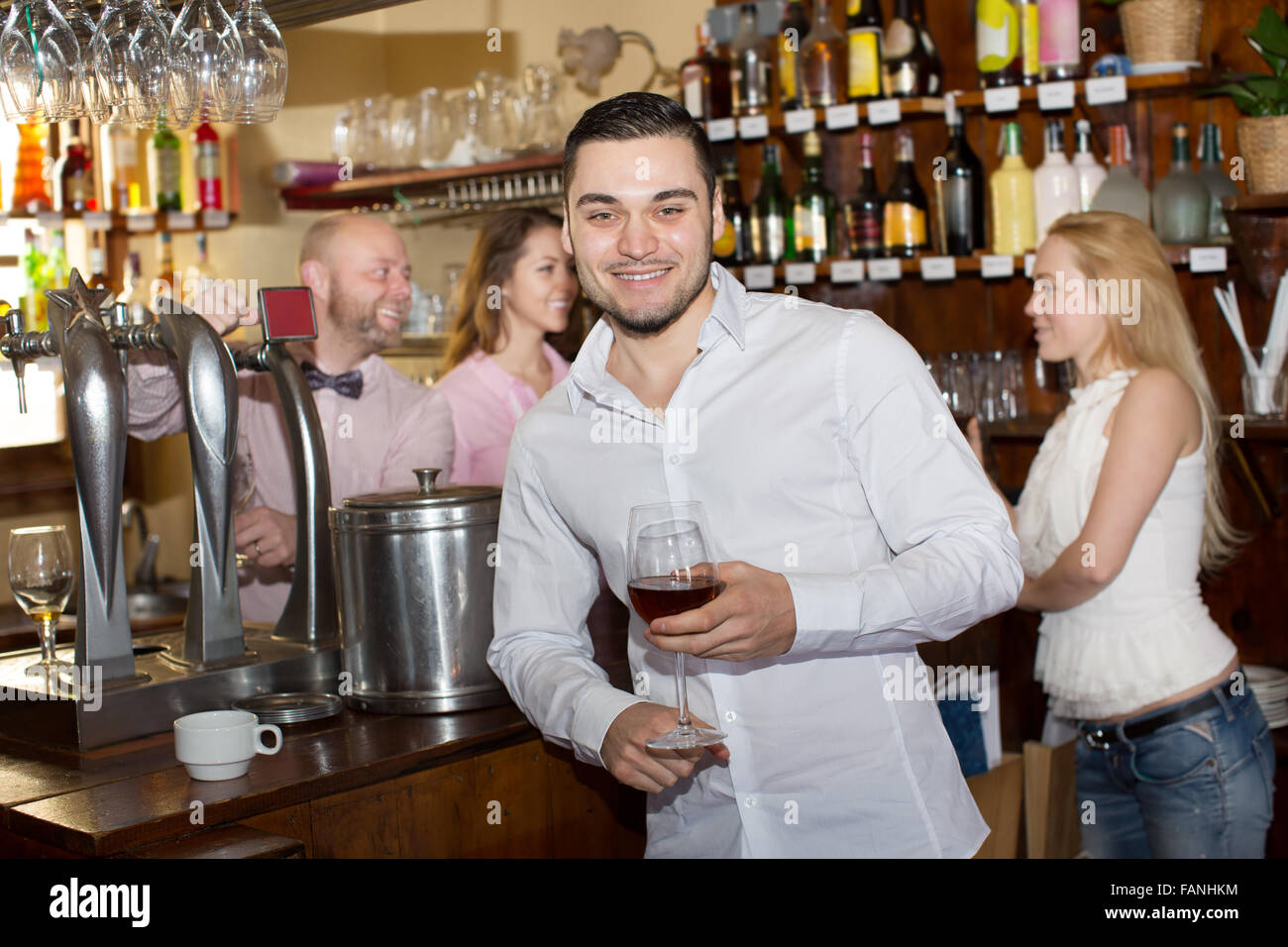 Positive bartender entertaining guests at a bar counter Stock Photo - Alamy