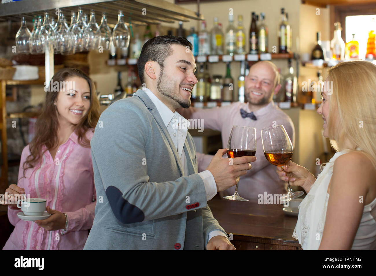 Happy bartender entertaining guests at the bar counter in bar Stock ...