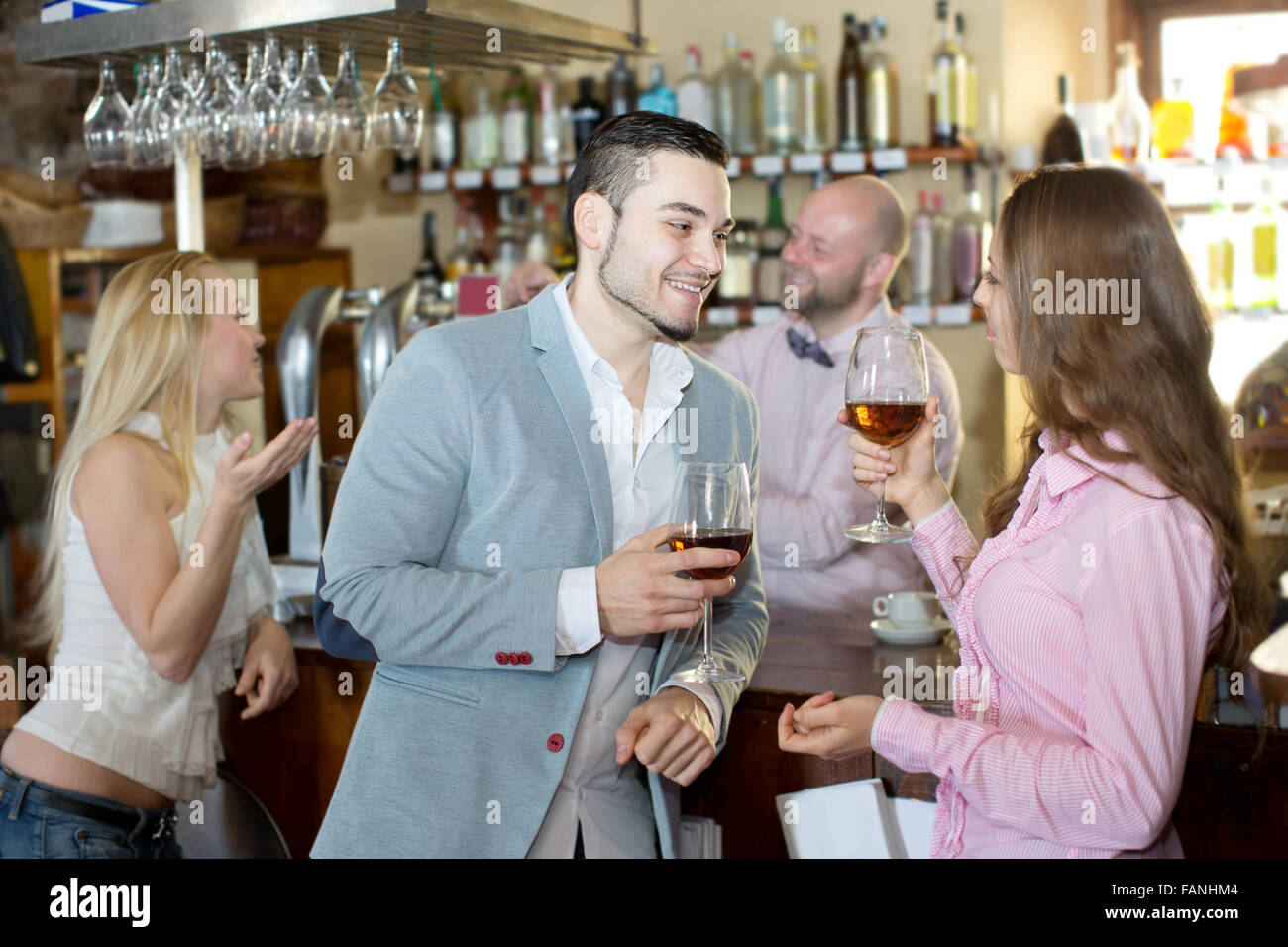 Restaurant young visitors waiting for table and drinking wine at tavern ...