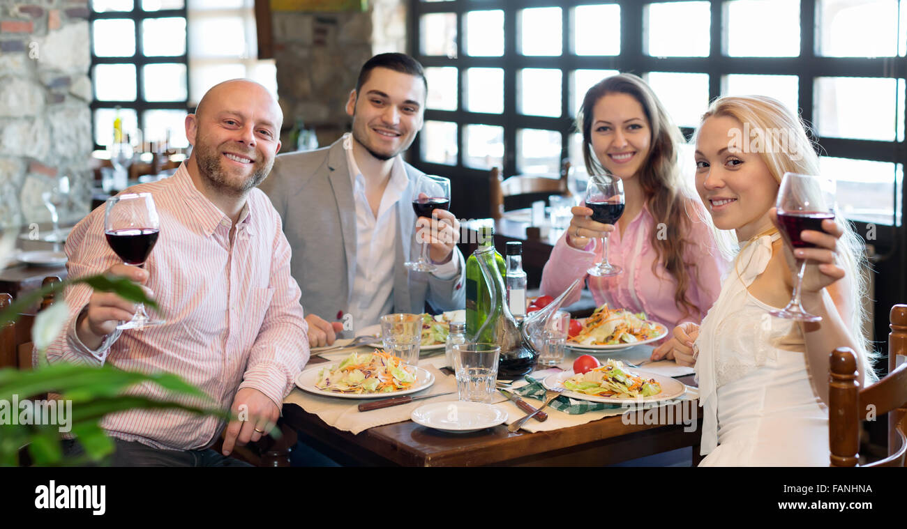 Four smiling people sitting at restaurant table Stock Photo - Alamy