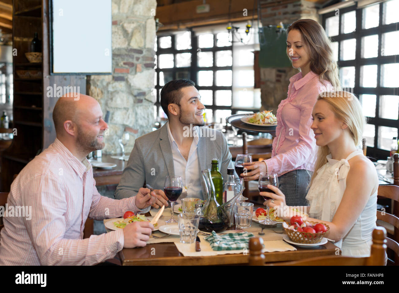 Happy group people having dinner at rural restaurant and drinking wine ...