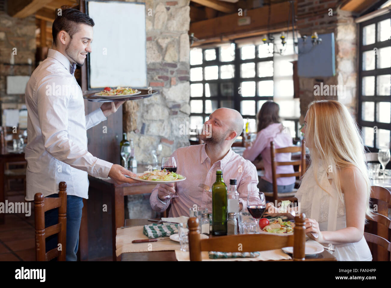 smiling people having dinner at rural restaurant. Focus on the man ...