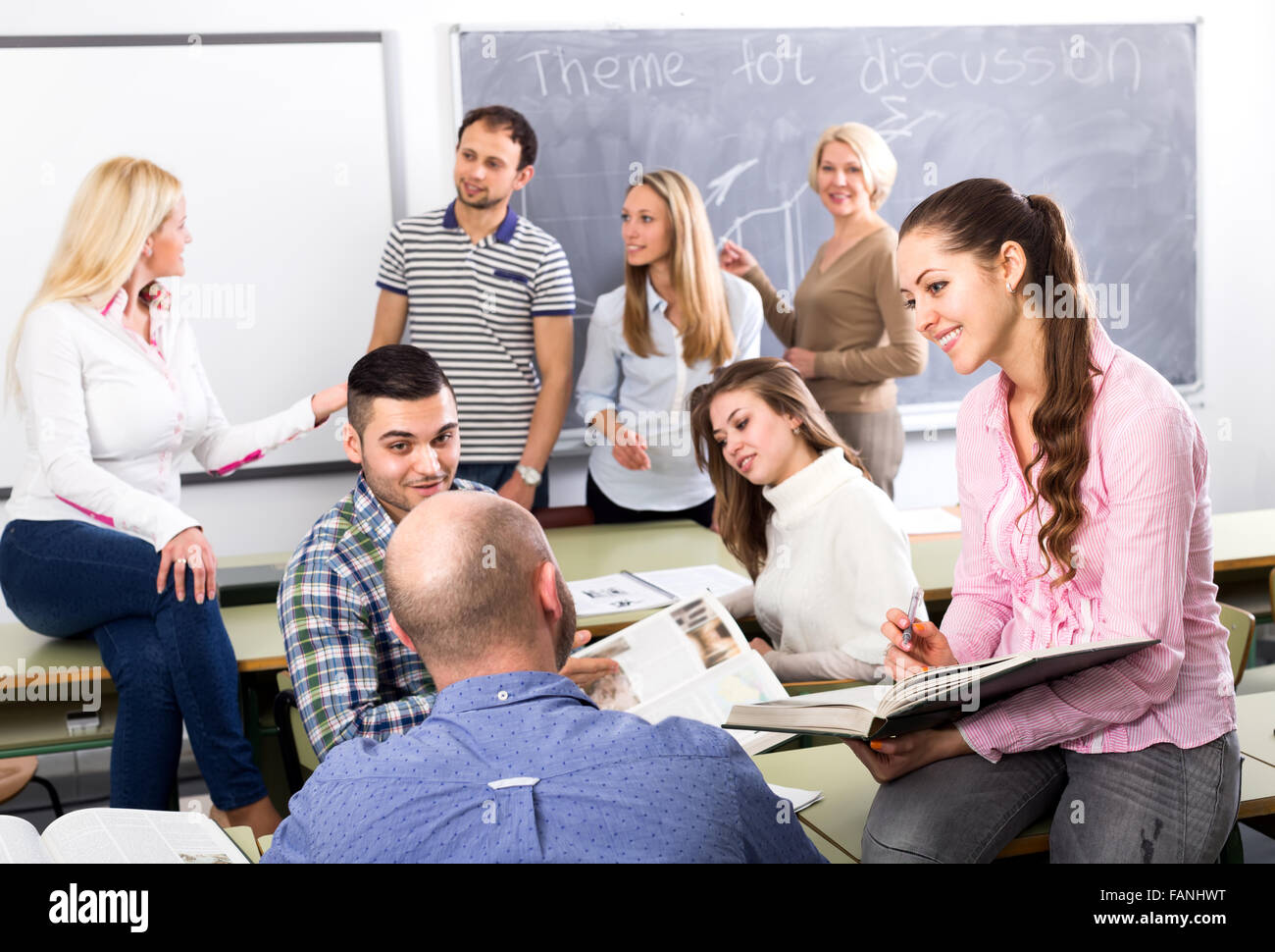 Teacher explaining interesting topic to curious students during a break ...