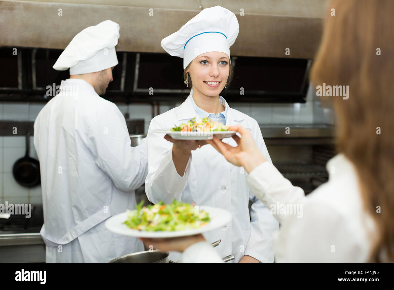 Team of positive chefs and young waiter at the restaurant kitchen Stock ...