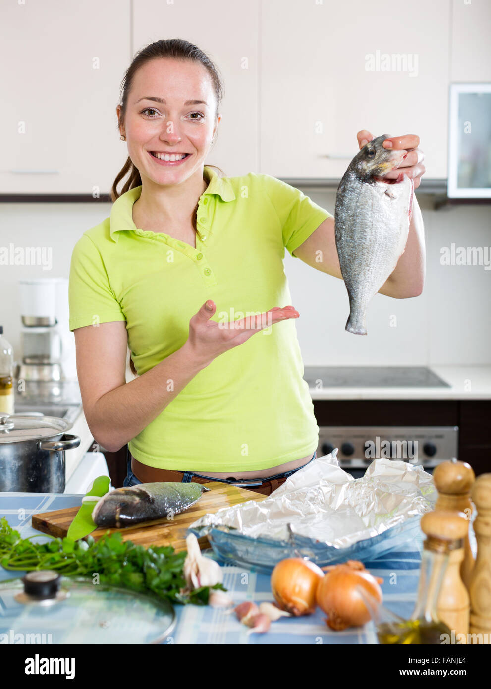 Happy blonde girl cooking fish hi-res stock photography and images - Alamy