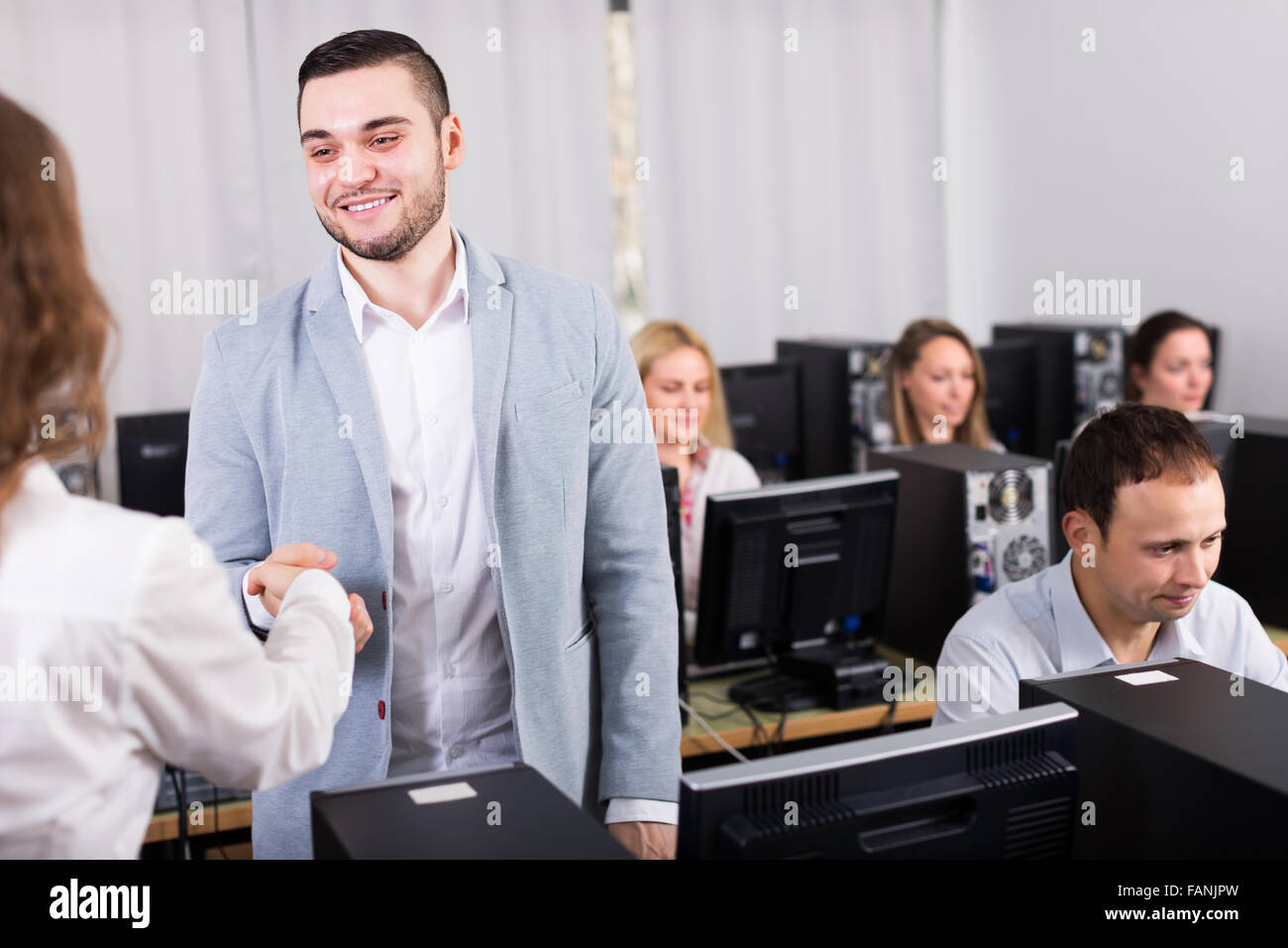 Friendly boss greeting new satisfied colleague at office Stock Photo ...