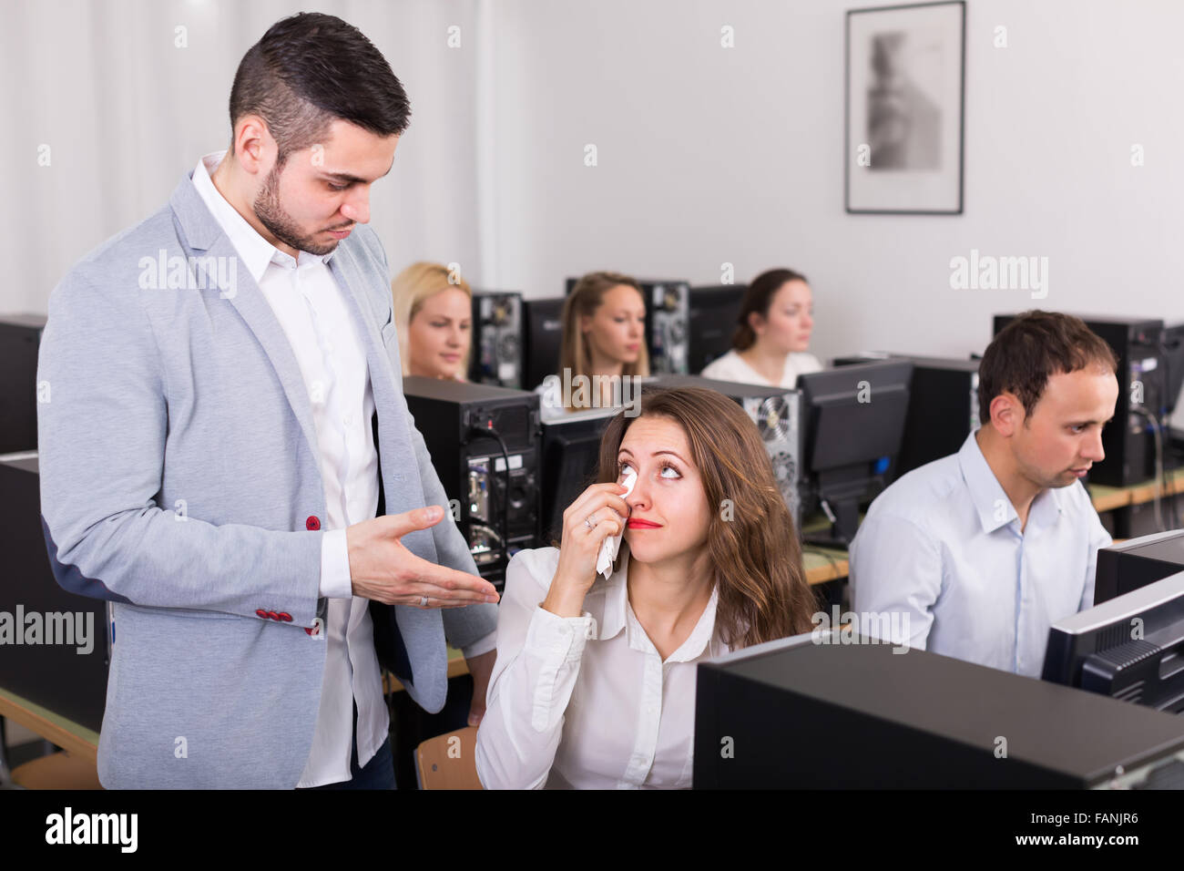 Displeased sales department manager scolding crying female in office ...