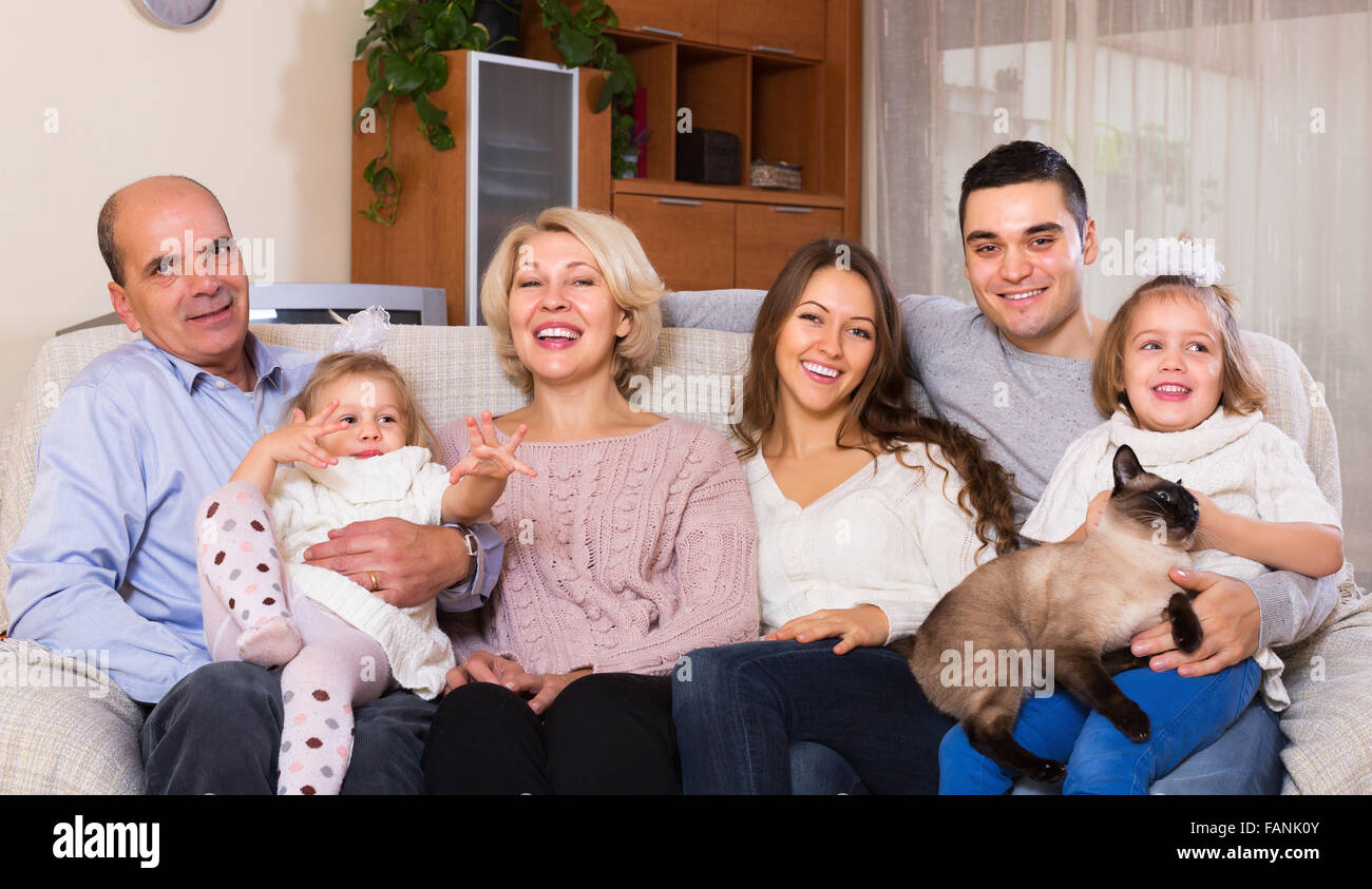 Smiling united family members together in living room Stock Photo - Alamy