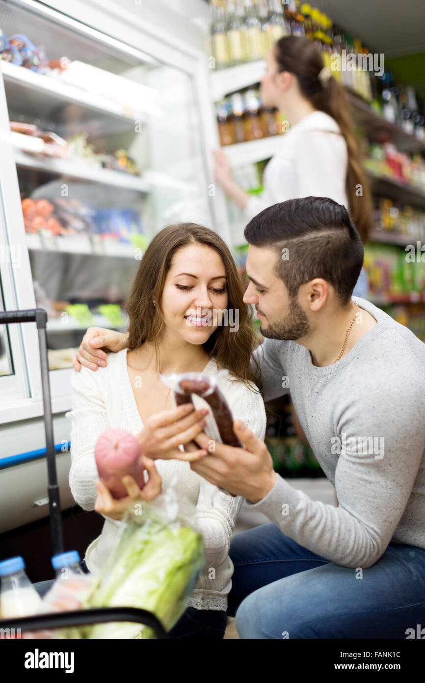 Smiling customers buying gammon and wurst at supermarket Stock Photo ...