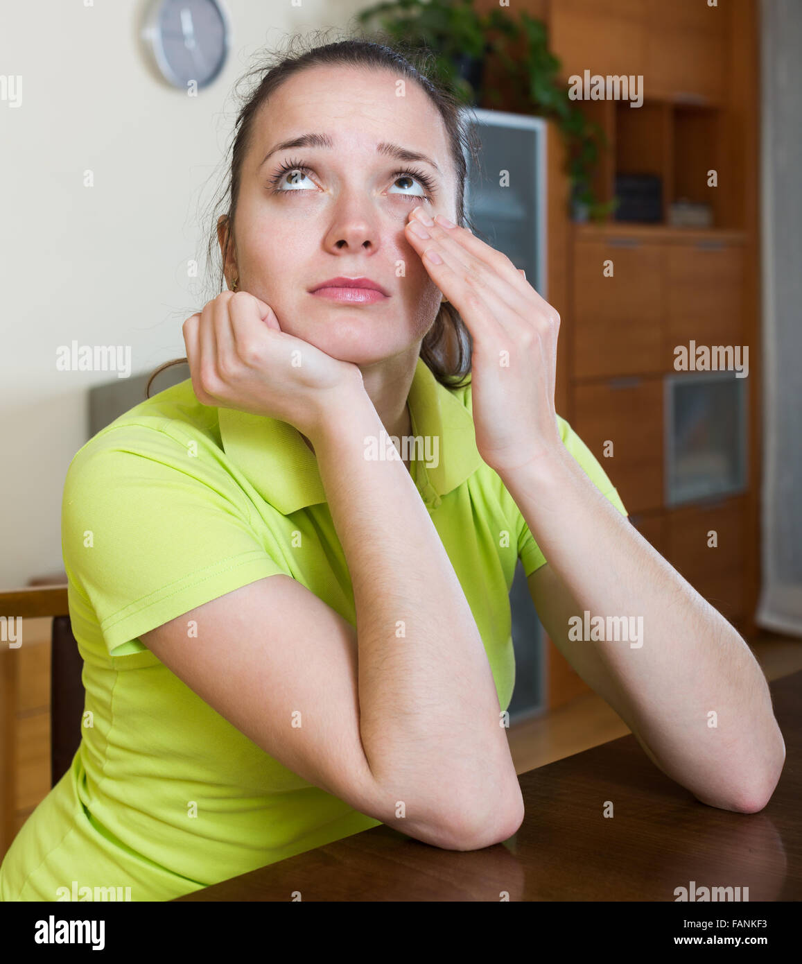 Depressed female sitting in a silence and thinking about her problems ...