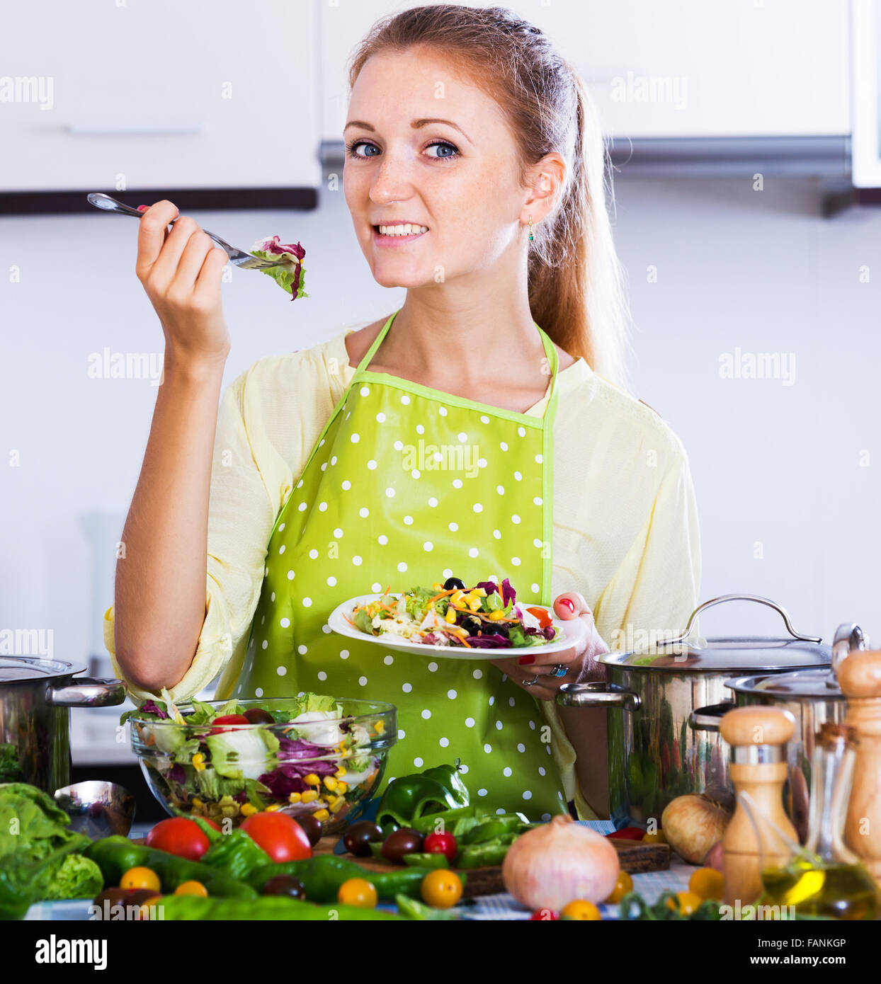 Positive girl tasting vegetable salad she cooked indoors Stock Photo ...