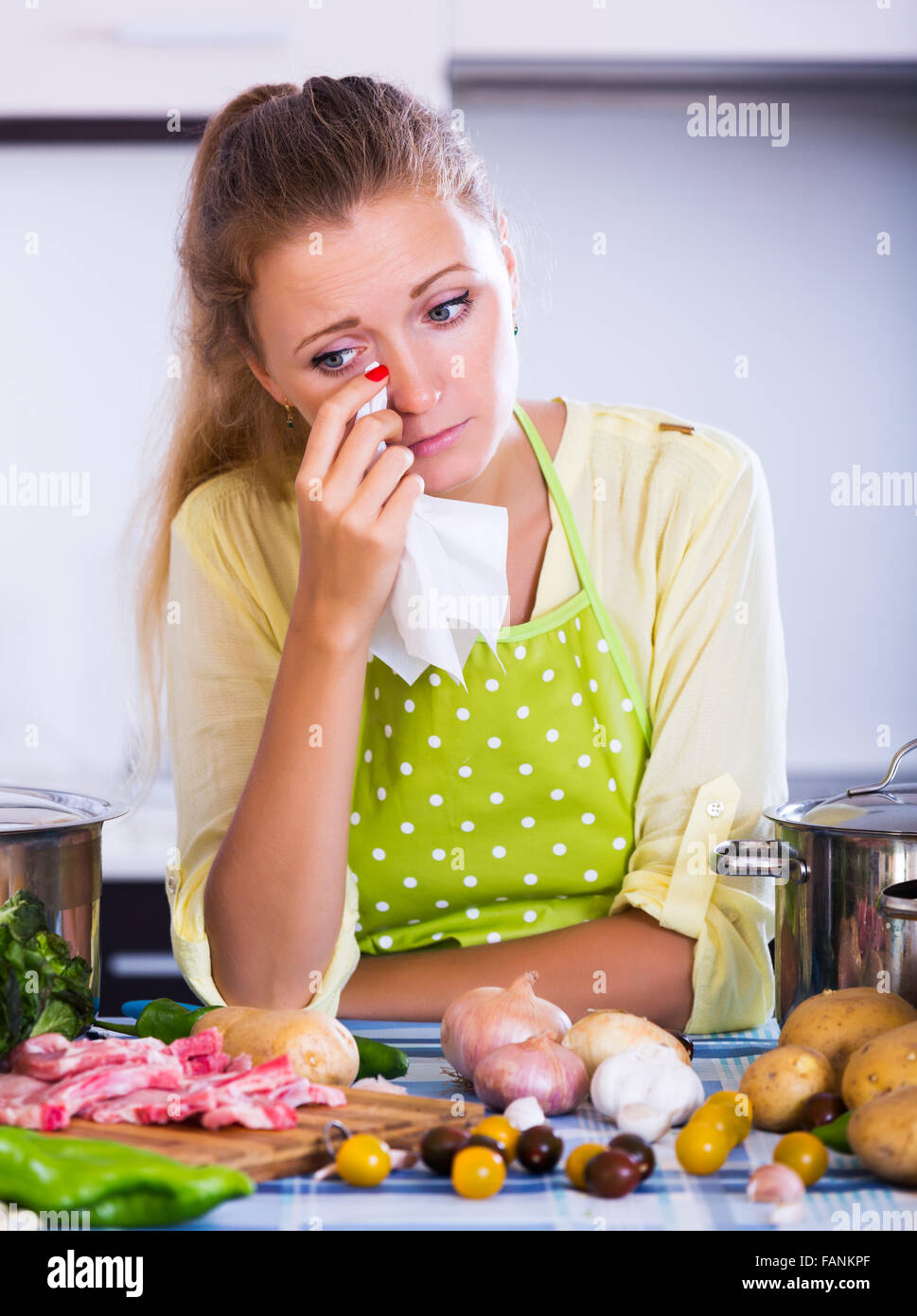 Frustrated blonde girl looking at dinner ingredients with sad face at ...