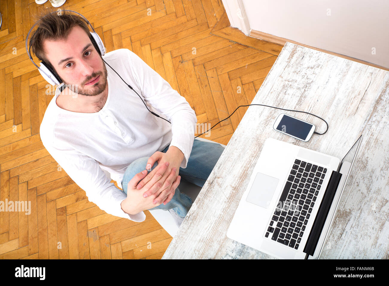 A young man listening to music on his Laptop computer Stock Photo - Alamy