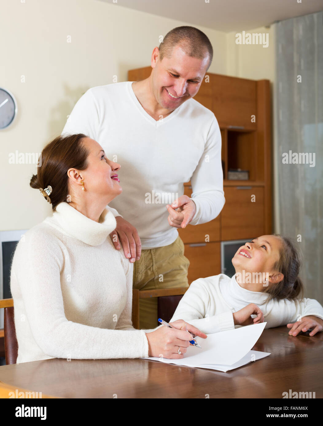 Happy parents and child with documents at table Stock Photo - Alamy