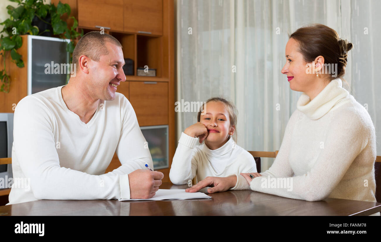 Happy parents and their child with documents at the table Stock Photo ...