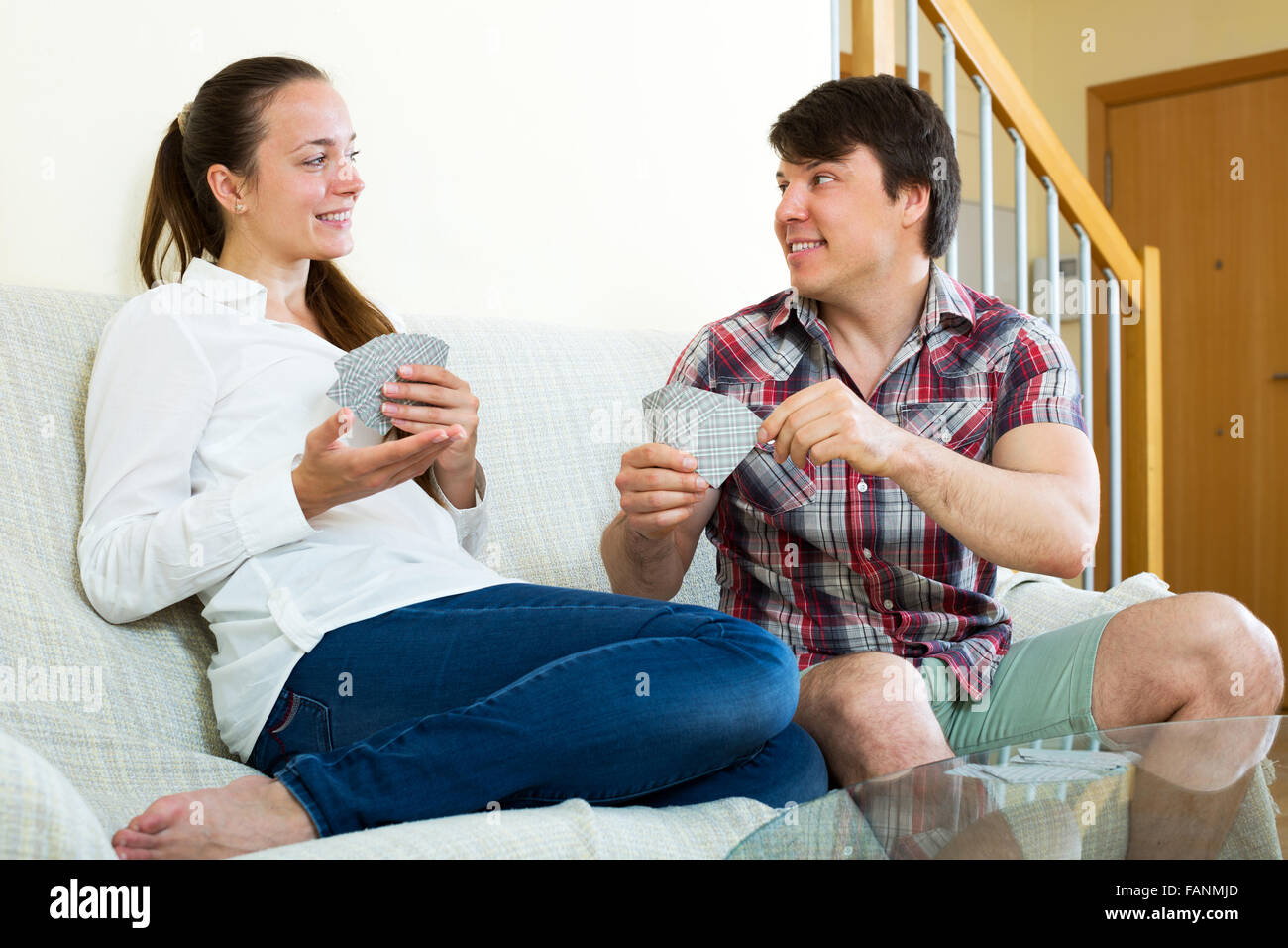 Man and woman playing cards sitting in a cosy room Stock Photo - Alamy