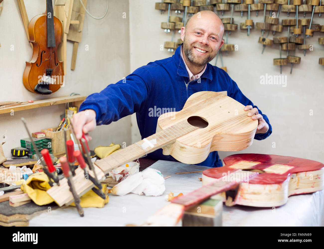 Portrait of successful professional carpenter in blue robe posing with ...