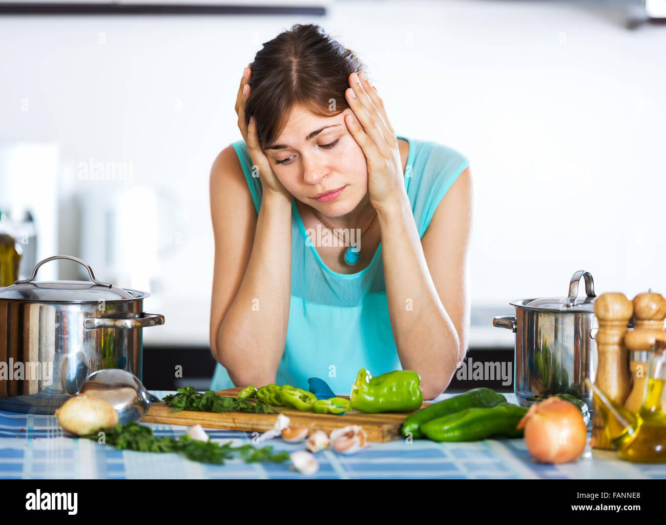 Young woman with sad face cooking dinner at home interior Stock Photo ...