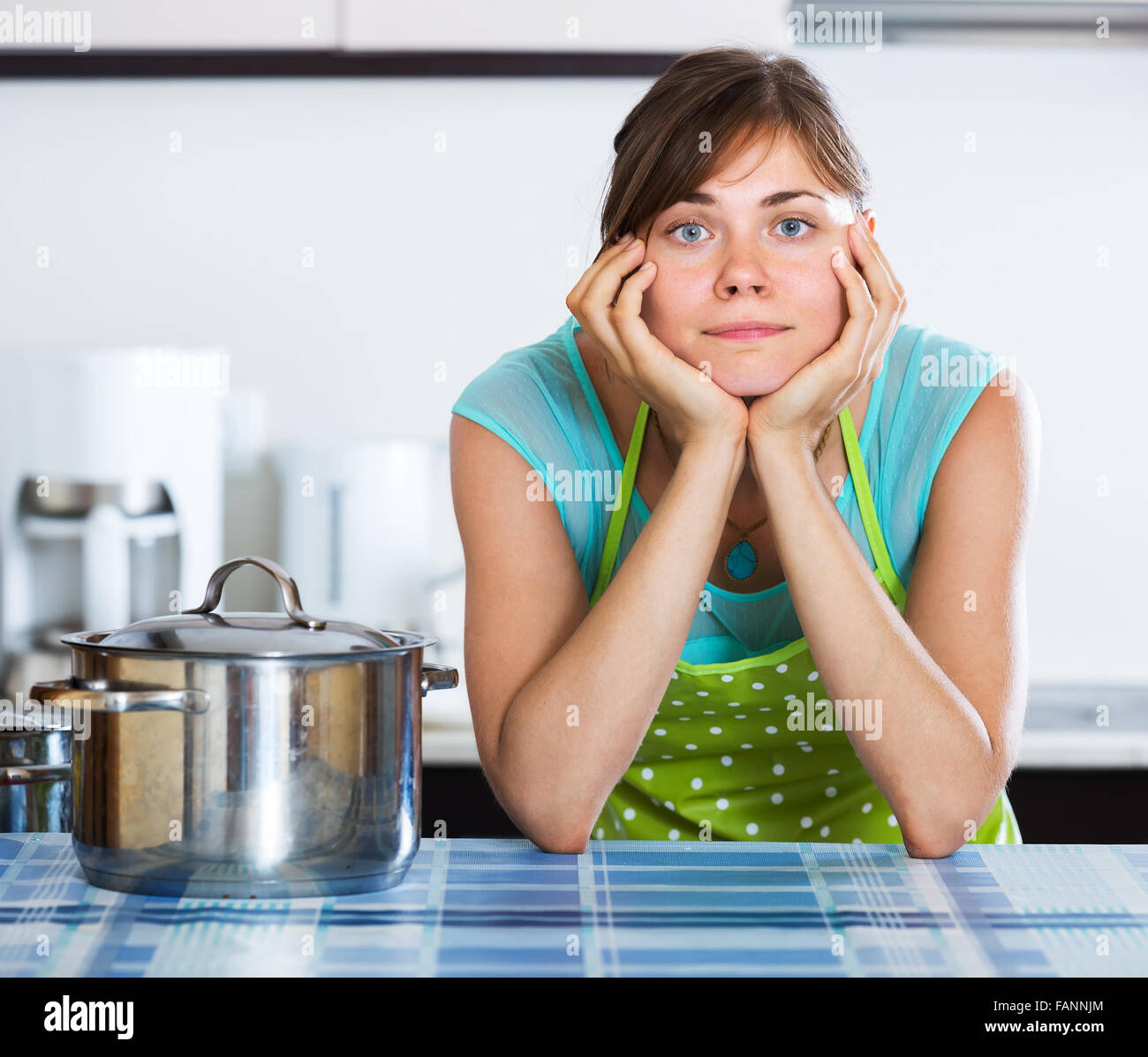 Young woman with sad face cooking dinner at home Stock Photo - Alamy