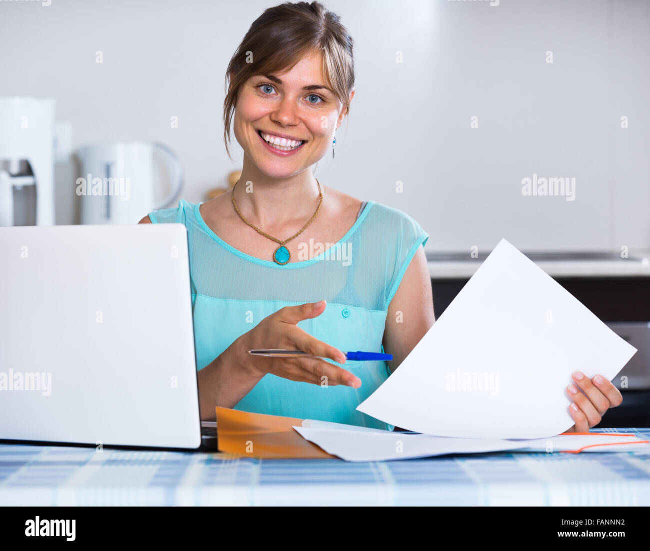 Young woman filling banking documents and smiling indoors Stock Photo ...