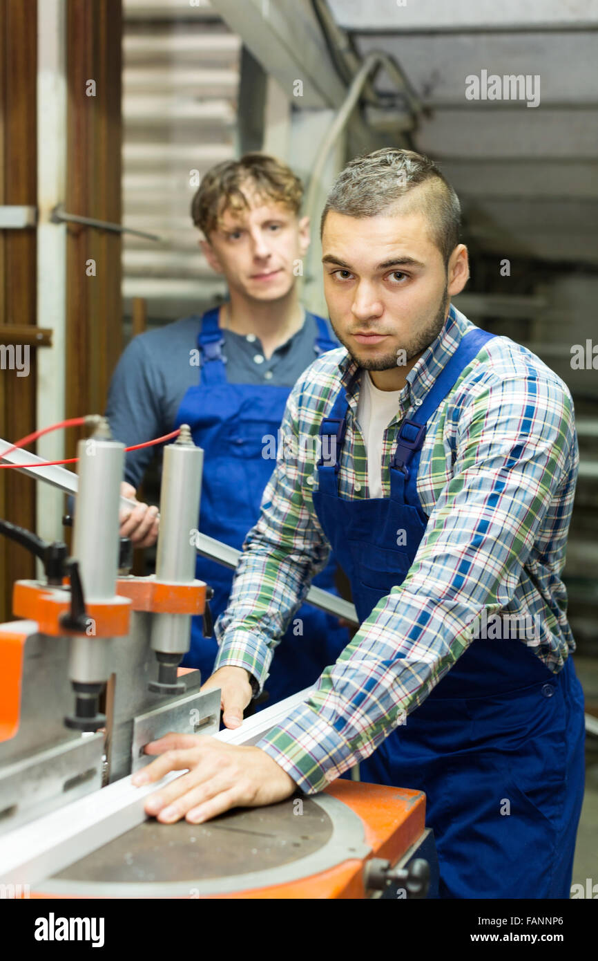 A couple of workers toil around the milling machine factory Stock Photo ...