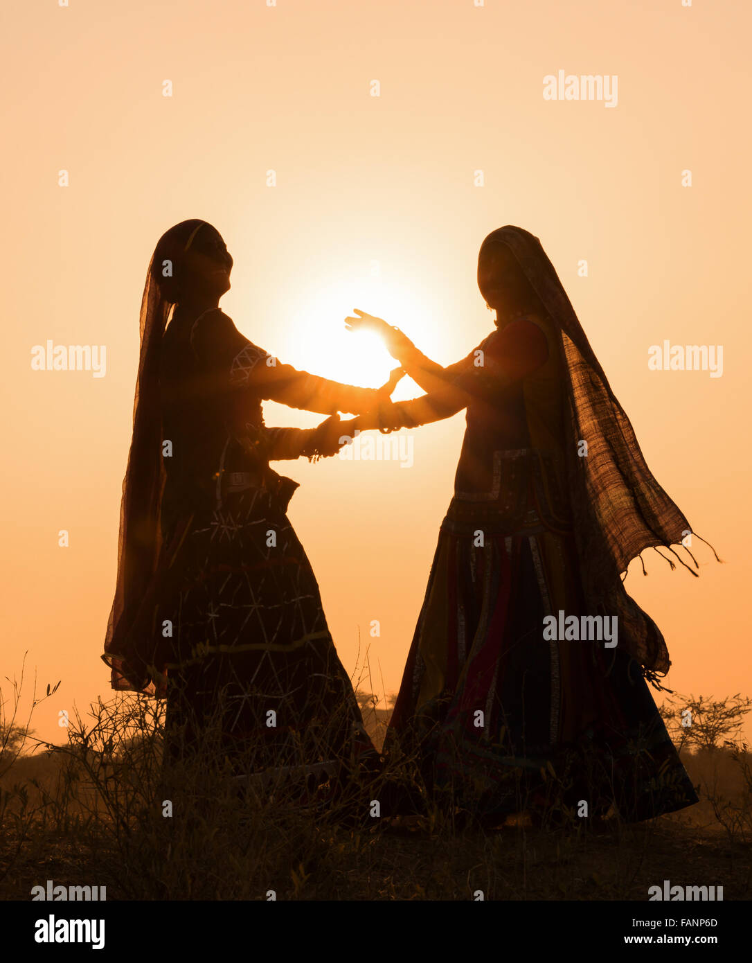 Silhouettes of two gypsy women dancing a traditional dance at sunset ...